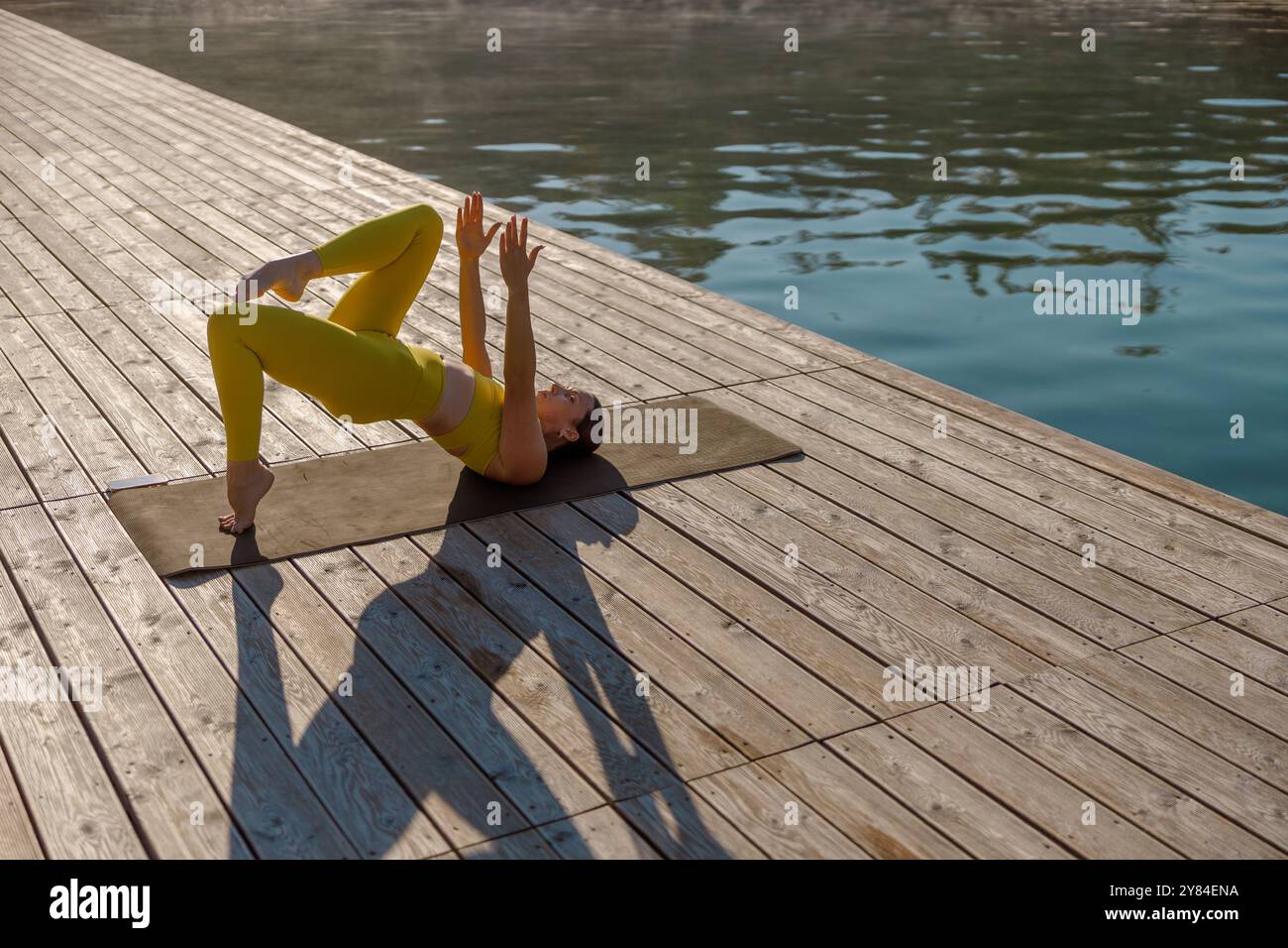 Engaging in a Dynamic Yoga Pose by the Water Embracing Serenity ...