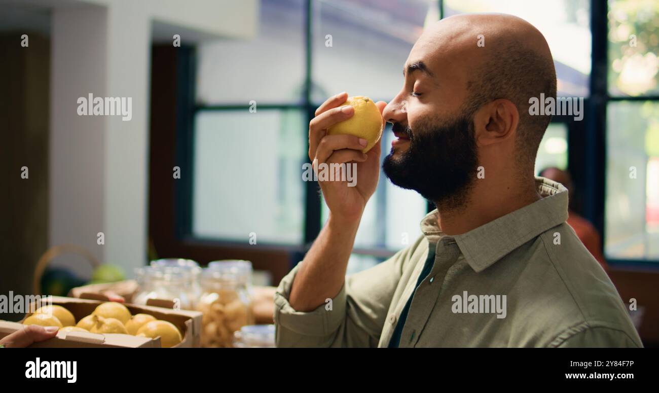 Buyer enjoying rich lemon smell from local organic supermarket, grocery ...