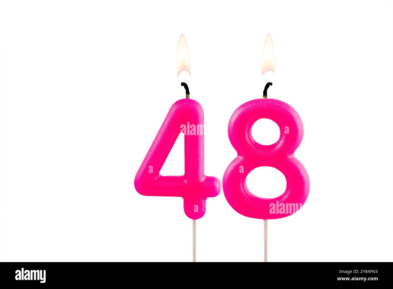 Pink number 48 birthday candle lit on white background Stock Photo - Alamy