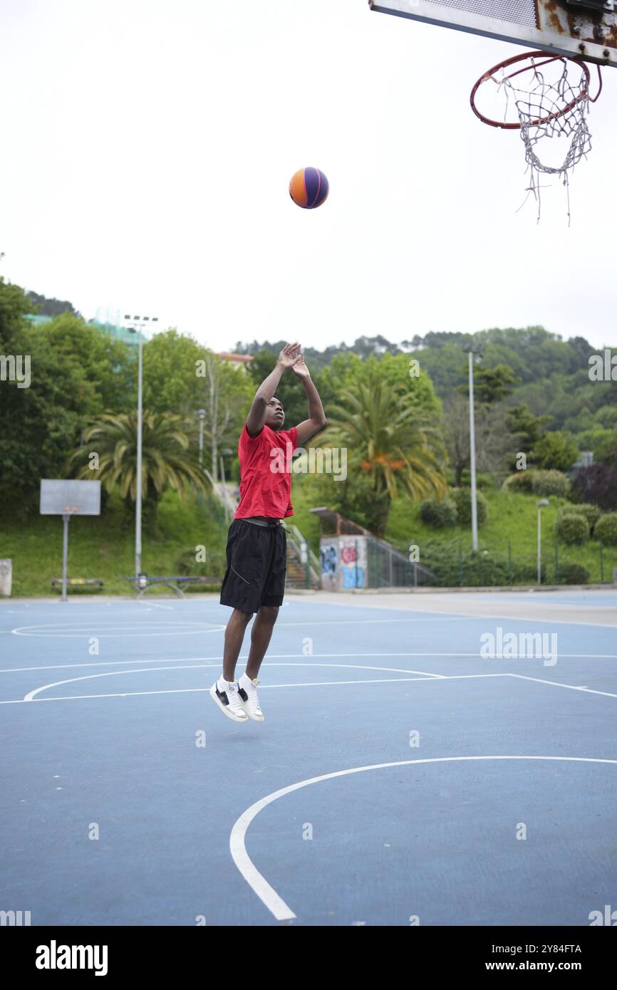 Vertical full length photo of an afro young basketball player training ...