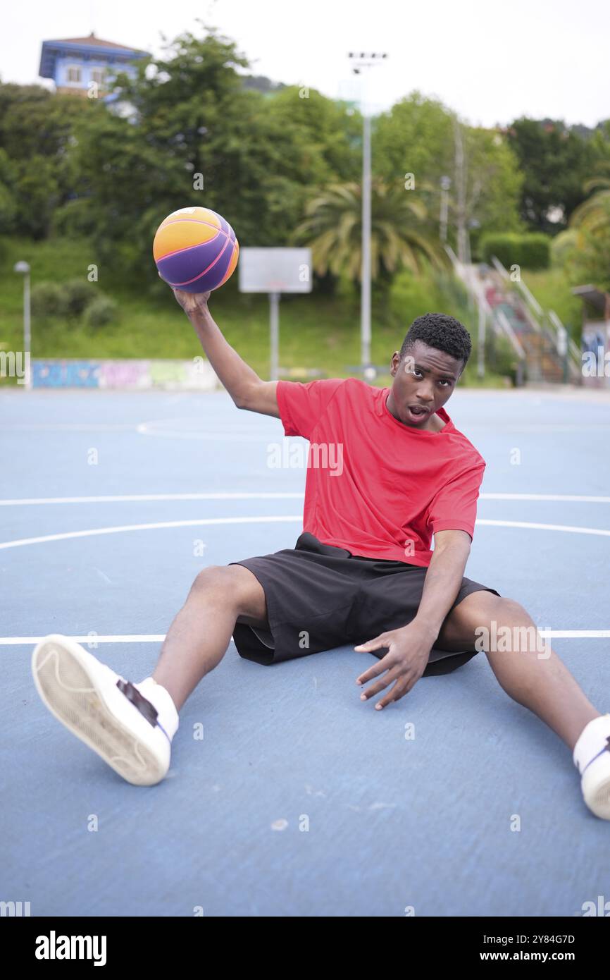 Vertical portrait of an African american basketball player resting ...