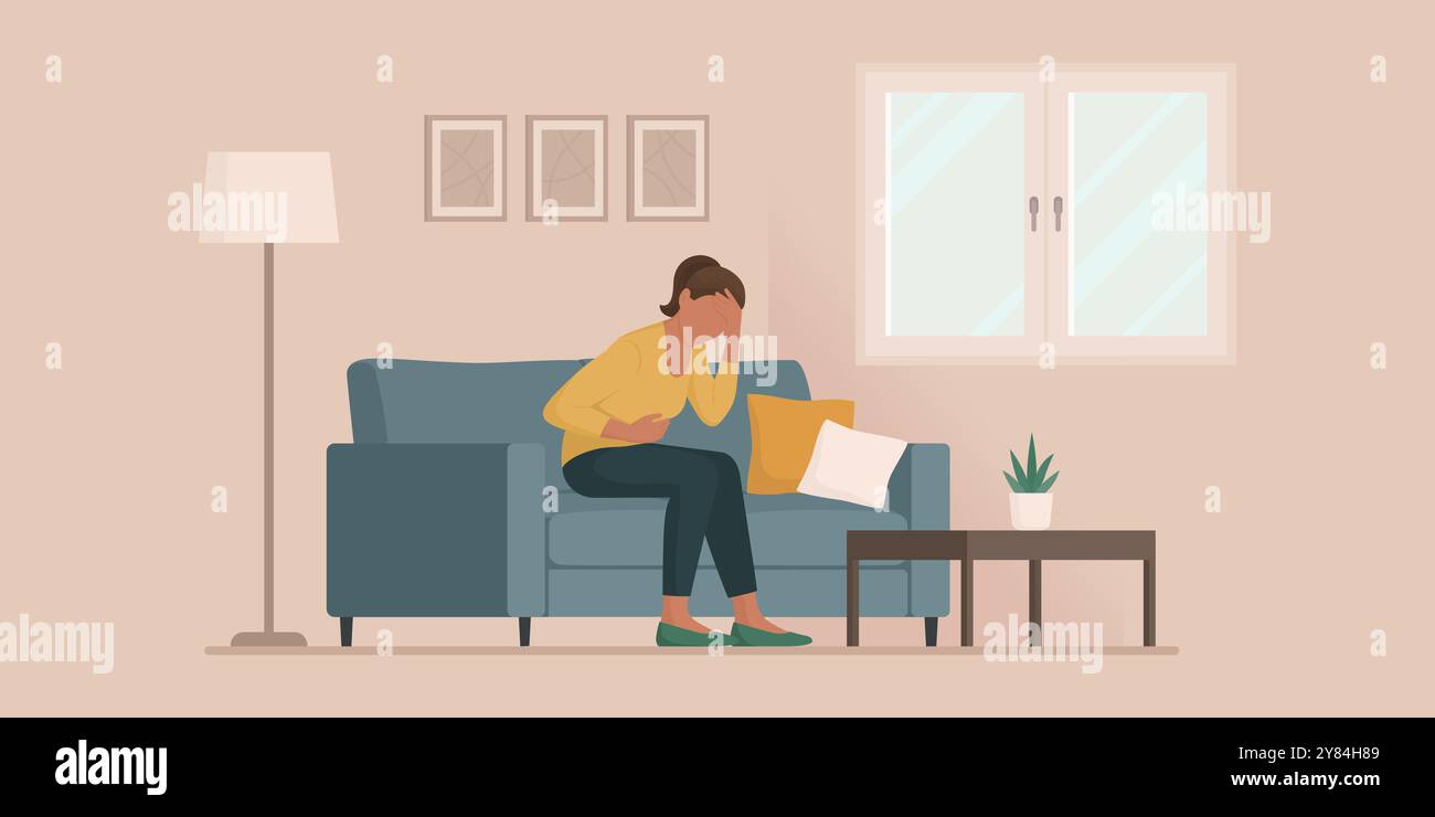 Sad woman sitting on the couch at home, she has a bad headache and ...