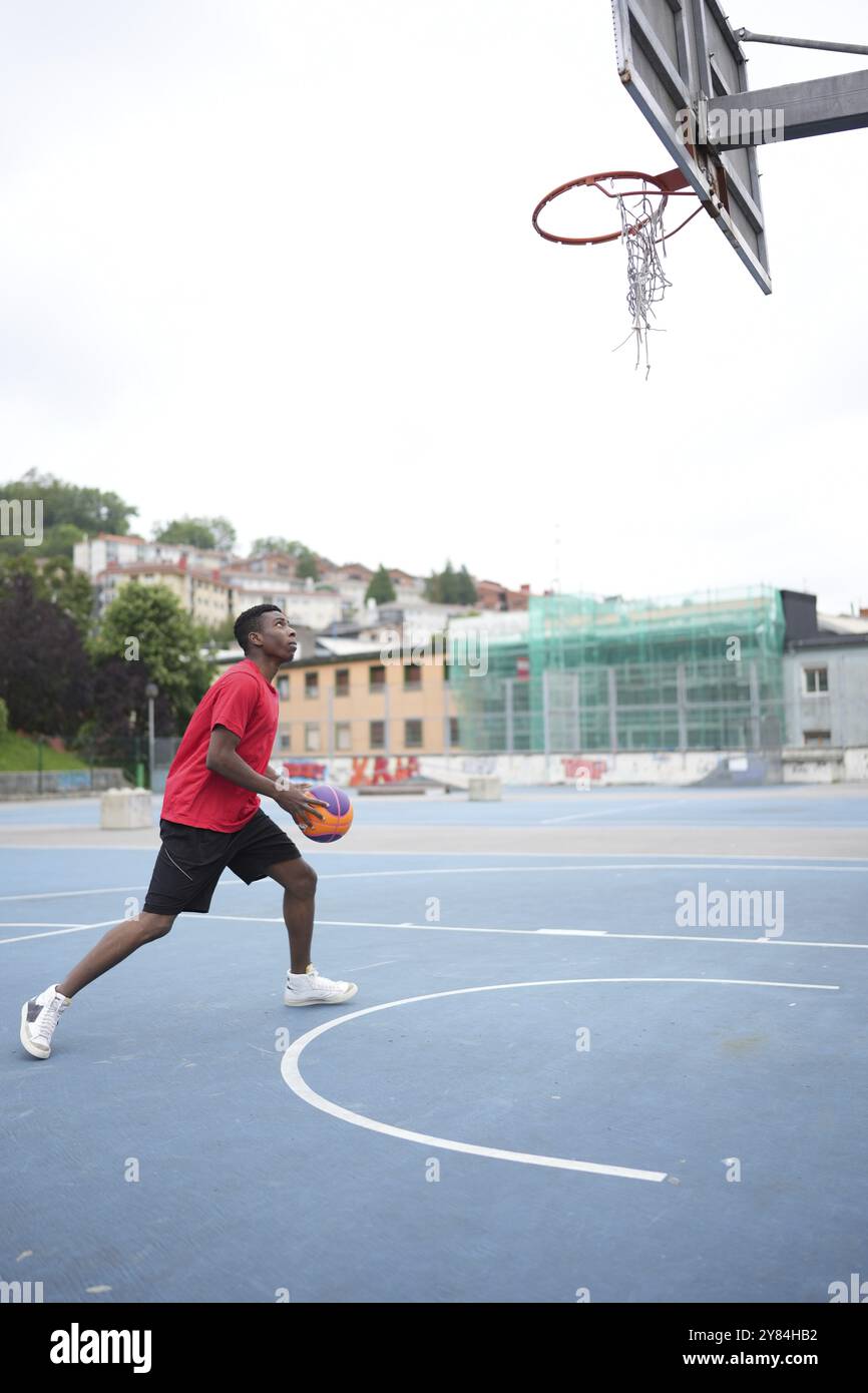 Vertical full length of an african american basketball player training ...