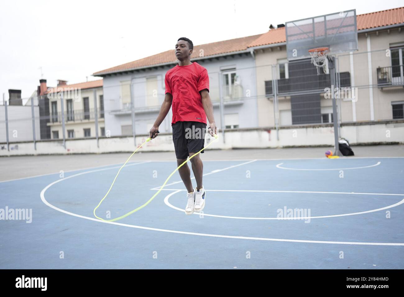 Young man of african descent warming up with jumping rope in an outdoor ...