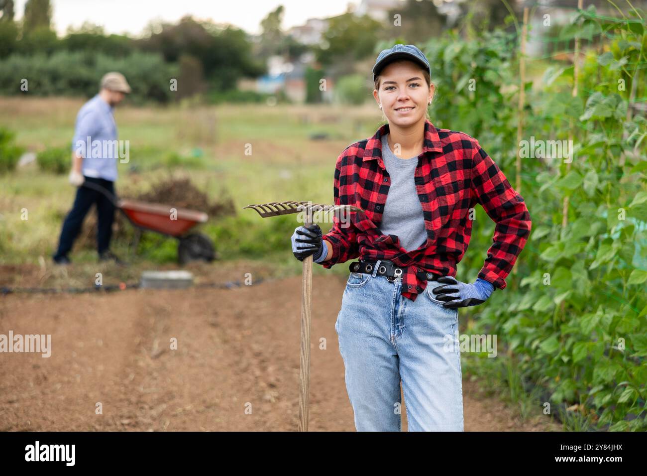 Peasant girl is working in garden with rake Stock Photo - Alamy