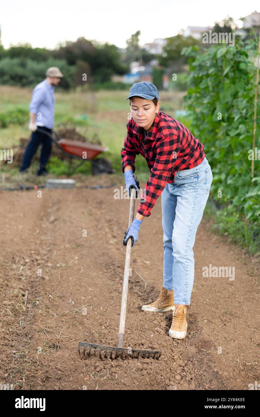 Peasant girl is working in garden with rake Stock Photo - Alamy