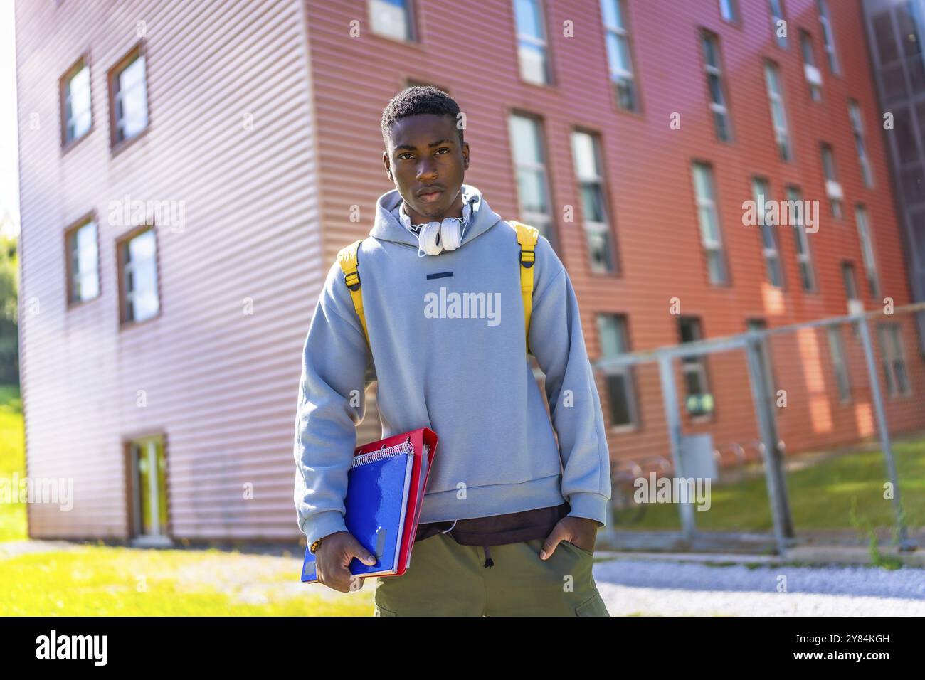Urban millennial african student standing carrying notebooks and ...