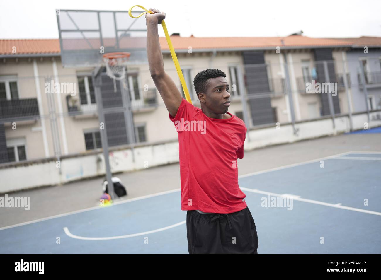 African young man stretching using elastic band in an outdoor ...