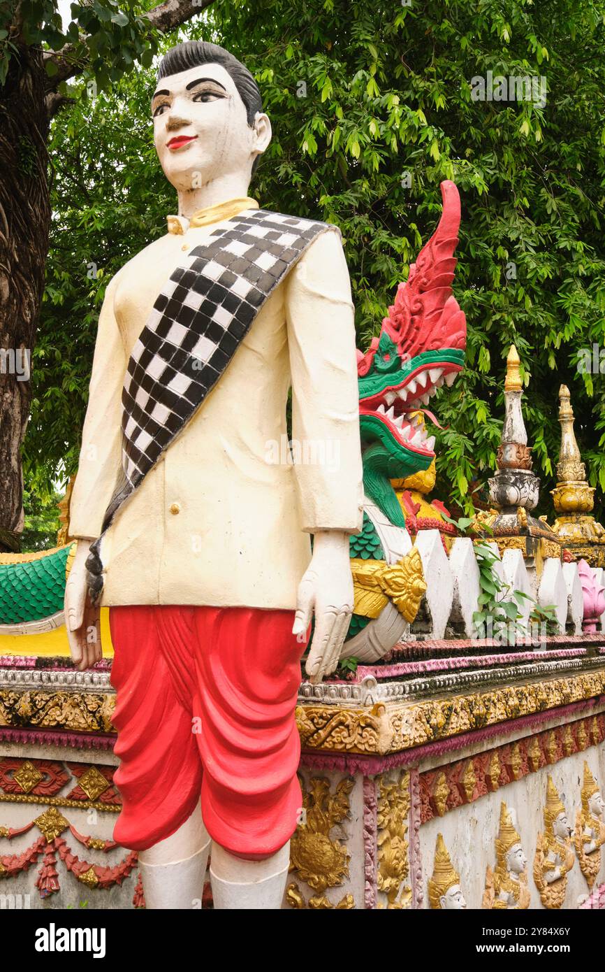 A guard figure with sash and dragon nearby. At Wat Si Muang Buddhist ...