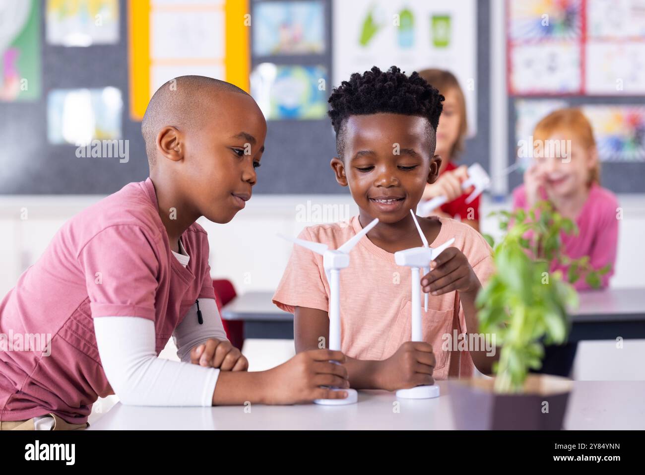 In school, diverse children studying wind turbines and renewable energy ...