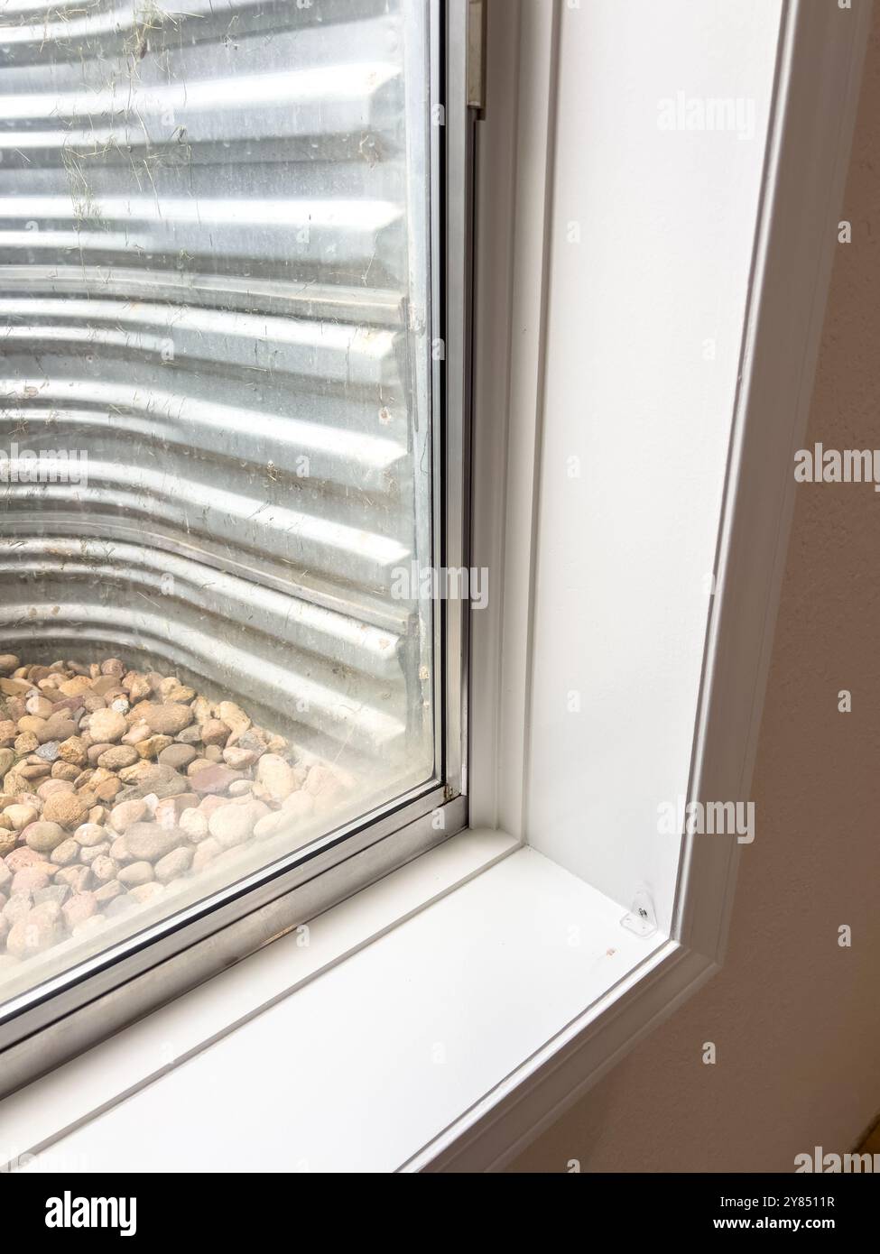 Basement Window with Metal Window Well and Rocks Stock Photo - Alamy
