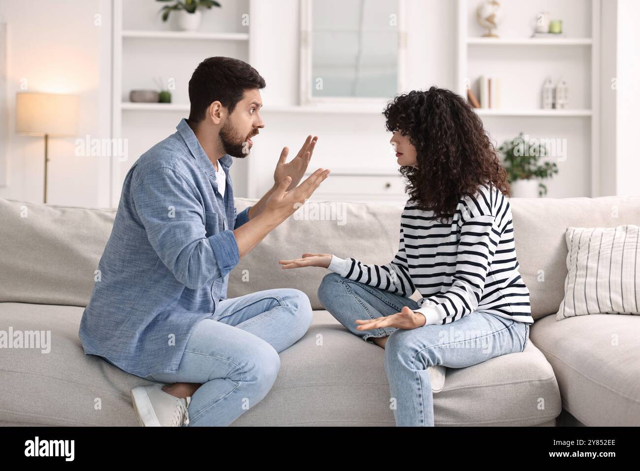 Emotional couple arguing on sofa at home. Relationship problems Stock ...