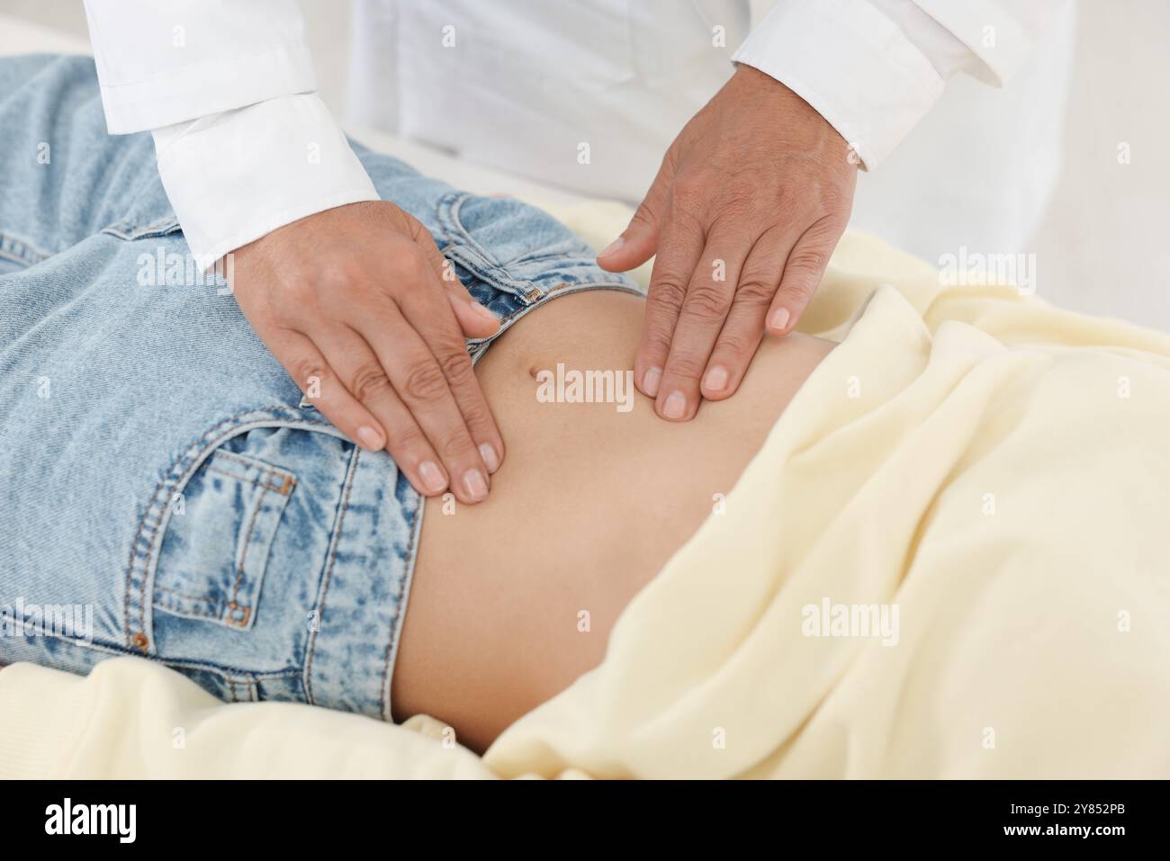 Doctor examining woman with stomach pain in clinic, closeup Stock Photo ...