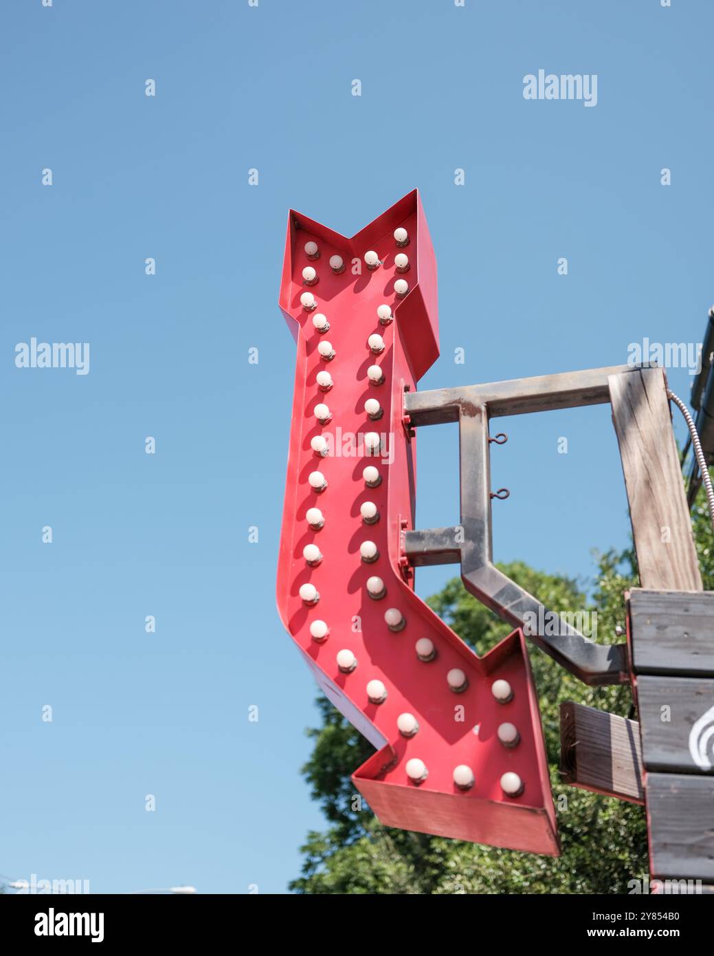 A red arrow sign in the daytime with blue sky. Cusomer, retail ...