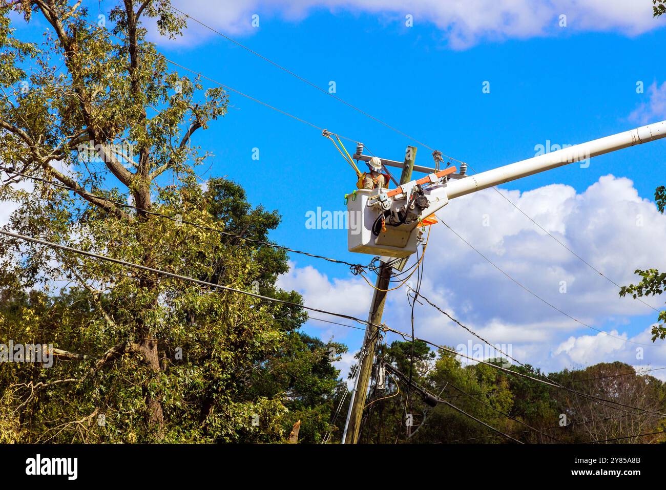 Utility tower truck is being used by emergency service linemen to ...