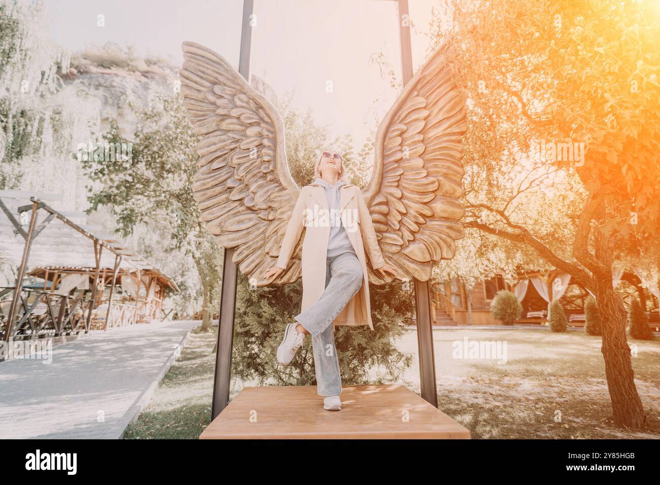 Woman Standing Underneath a Giant Angel Wing Sculpture Stock Photo - Alamy