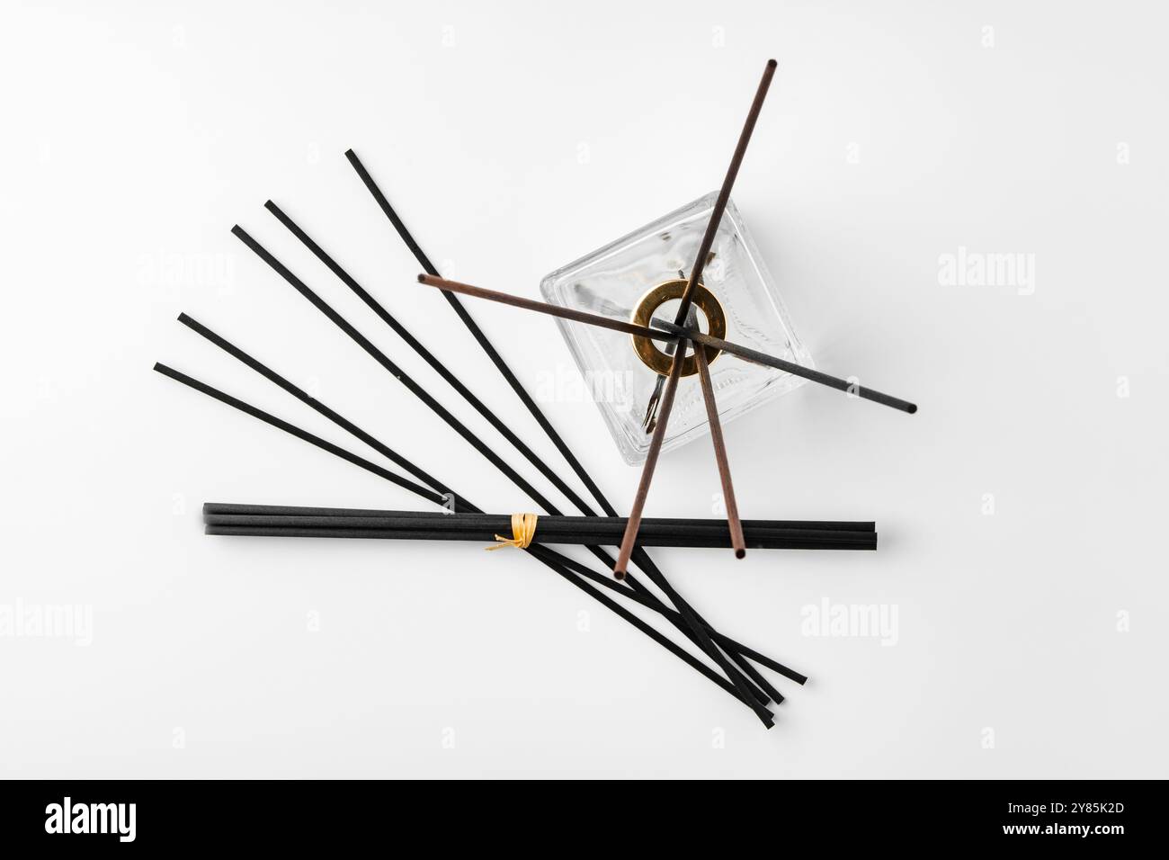 A minimalist display of essential oil and black diffuser sticks on a ...