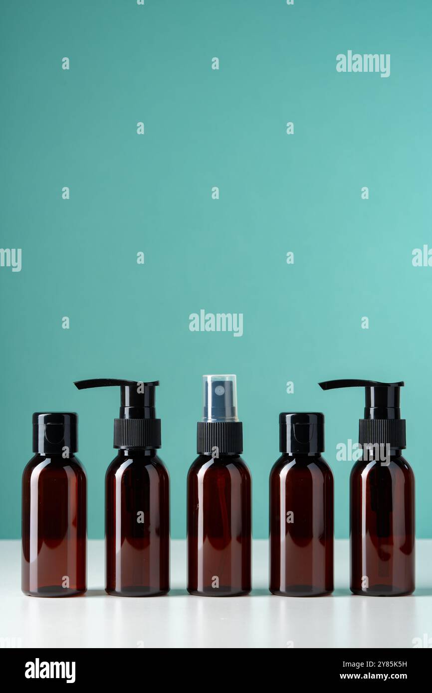 Collection of amber glass bottles with pumps and spray tops on a light ...