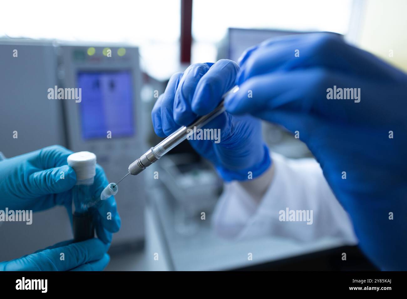 Scientist injecting a sample via the auto sampler of HPLC system Stock ...
