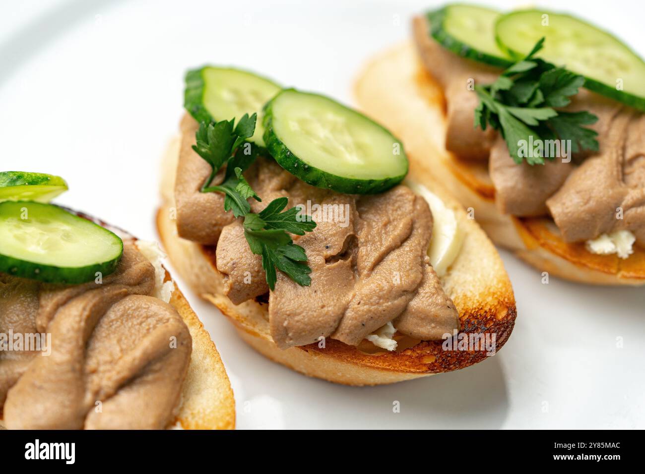 Savory canapes topped with creamy spread and cucumber slices served on ...
