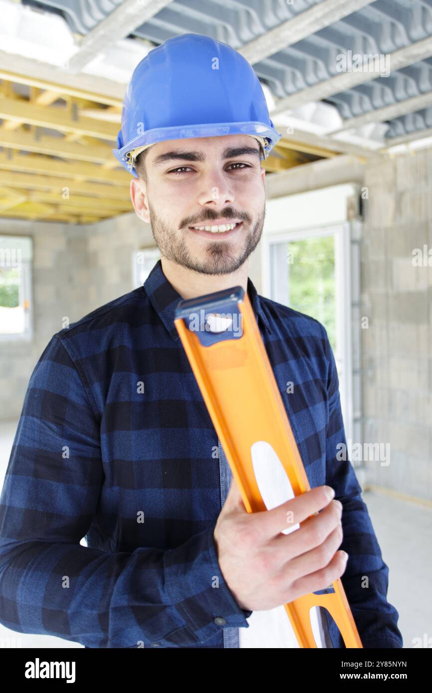 portrait of happy worker using spirit level Stock Photo - Alamy