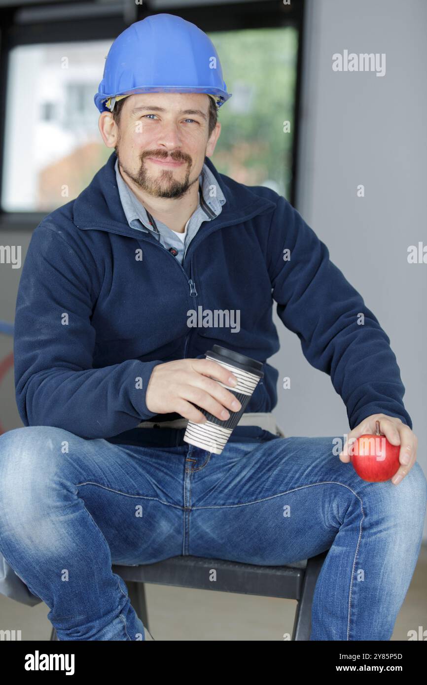 male construction worker eating apple Stock Photo - Alamy