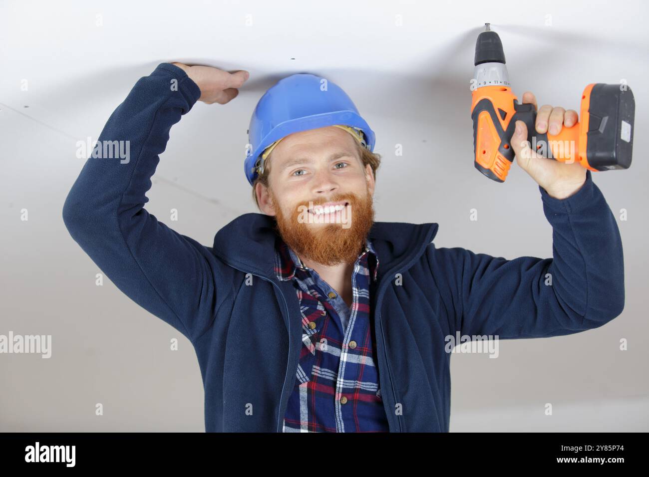 happy man drilling the ceiling Stock Photo - Alamy