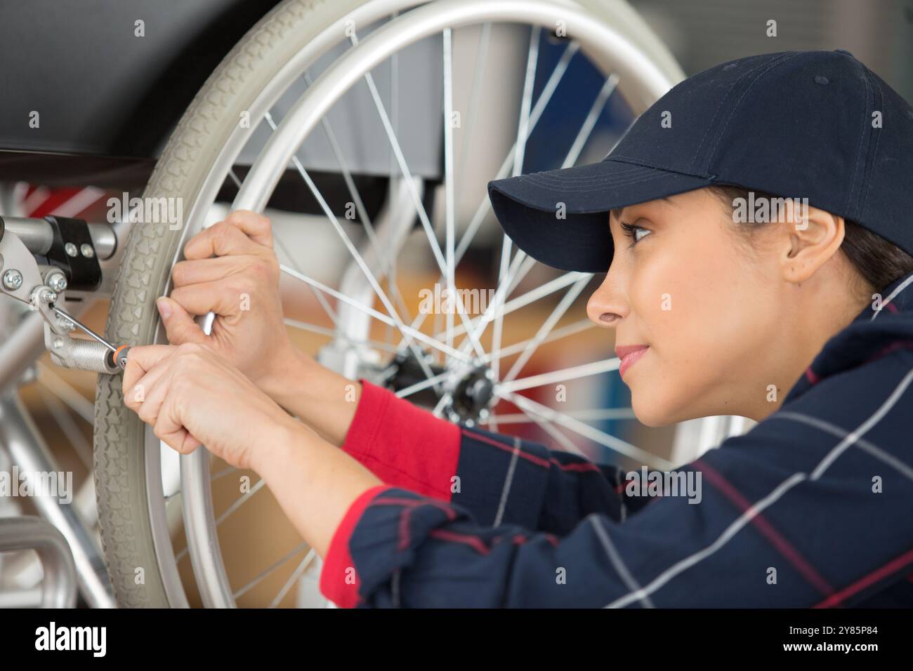 female worker adjusting brakes on a wheelchair Stock Photo - Alamy