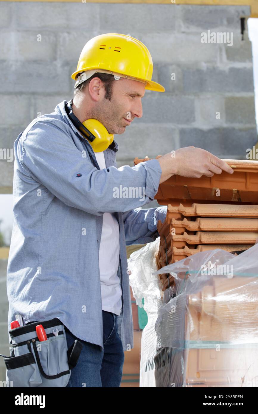 woman collecting tiles from an outdoor stack Stock Photo - Alamy