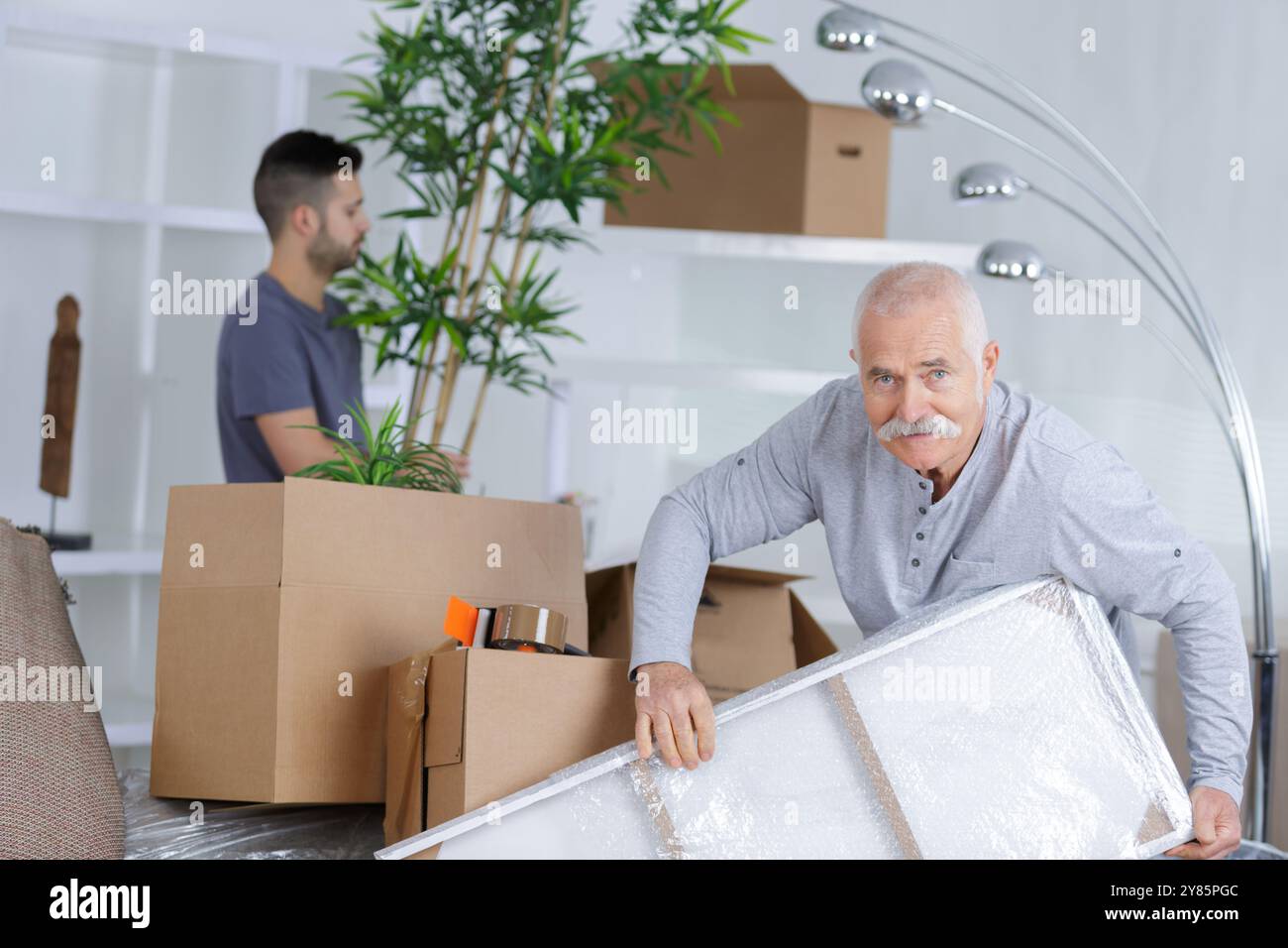 grandson helping his grandfather moving Stock Photo - Alamy
