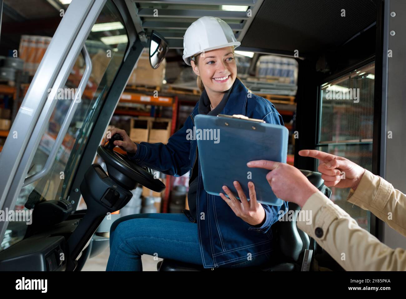 female forklift operator receiving oders Stock Photo - Alamy