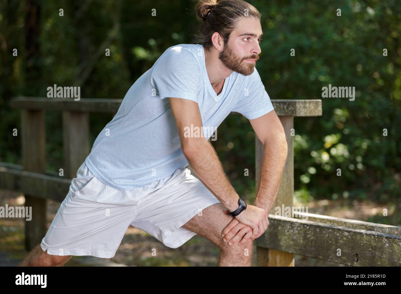 male jogger stretching his leg muscles Stock Photo - Alamy