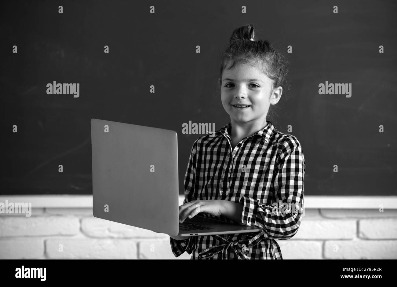 Cute little school kid girl study in a classroom. Online learning ...