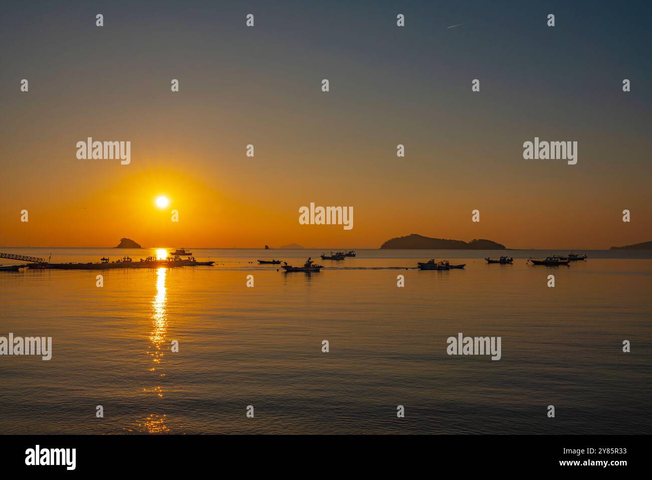 A peaceful sunrise at Jamjindo Island, Incheon. The golden sun reflects ...