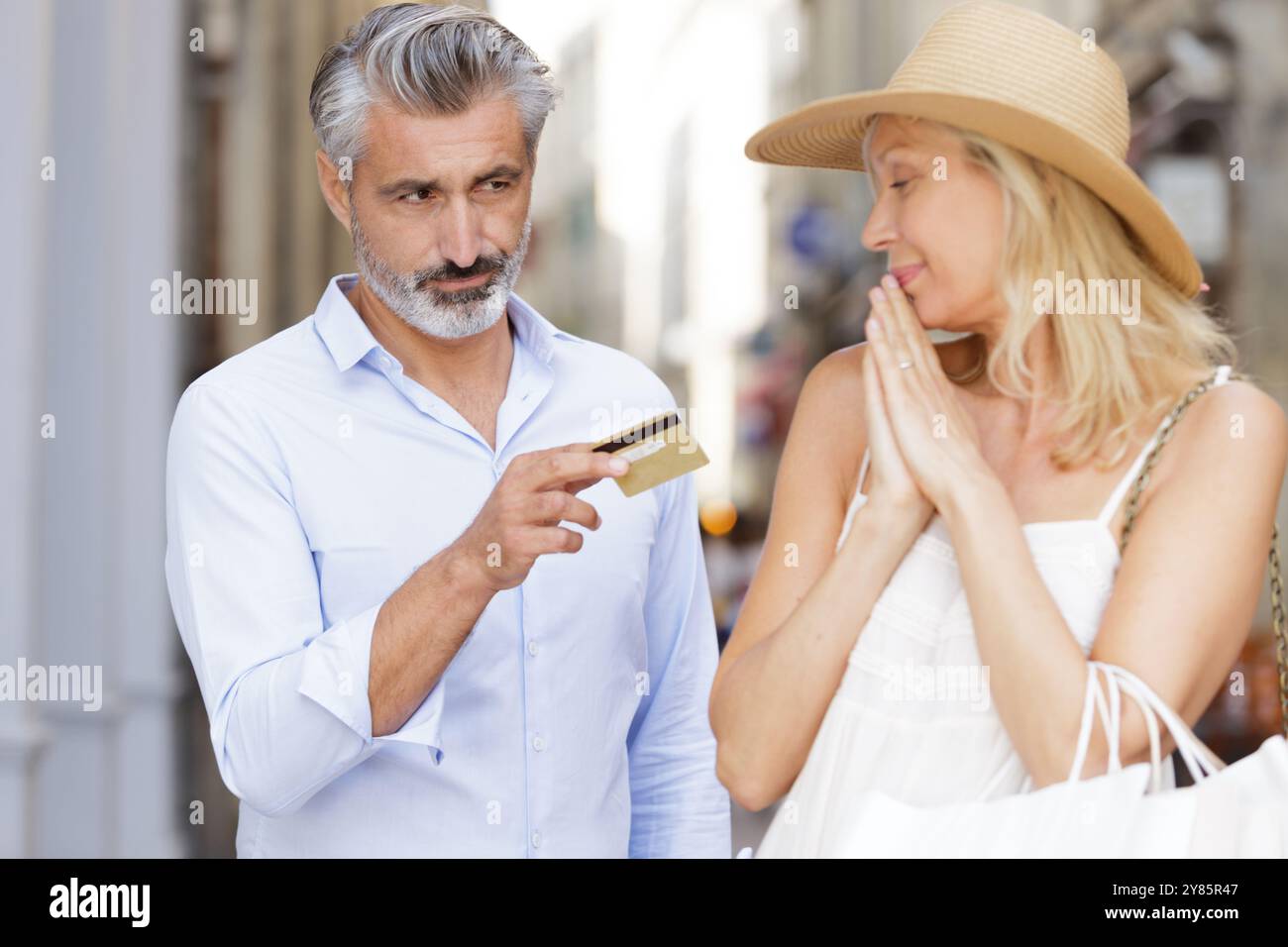 man reluctantly giving a credit card to his wife Stock Photo - Alamy
