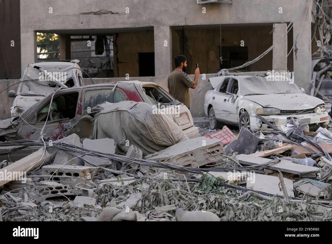A man documents the damaged buildings at the site of an Israeli ...