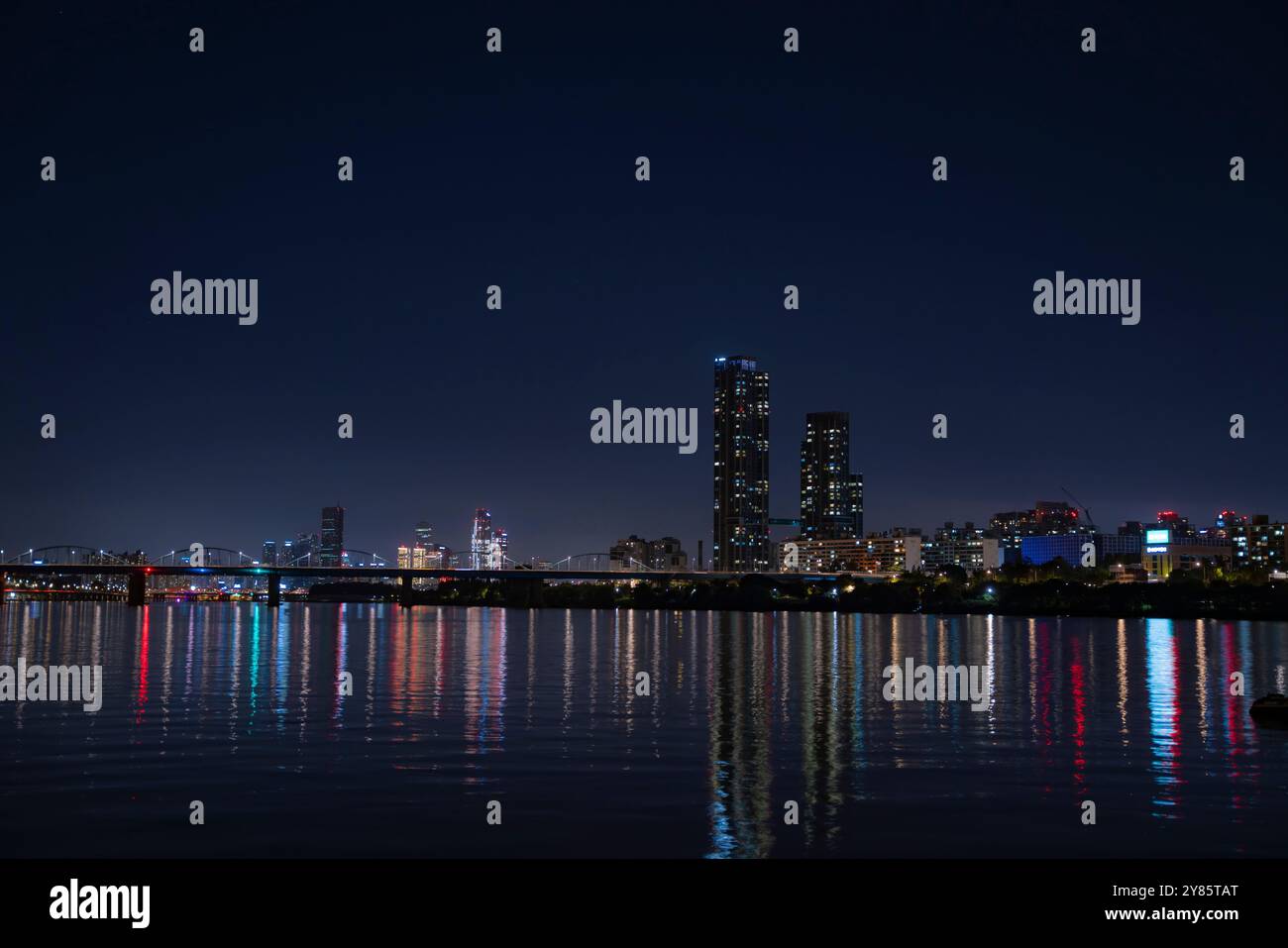 This photo shows the calm night view of the Han River, with city lights ...