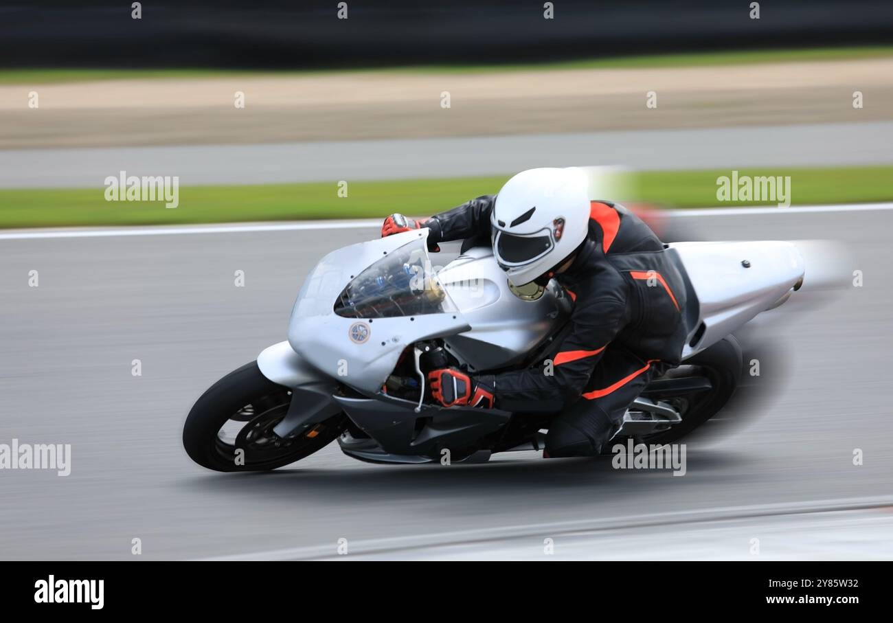 Racing bike rider leaning into a fast corner on the race track Stock ...