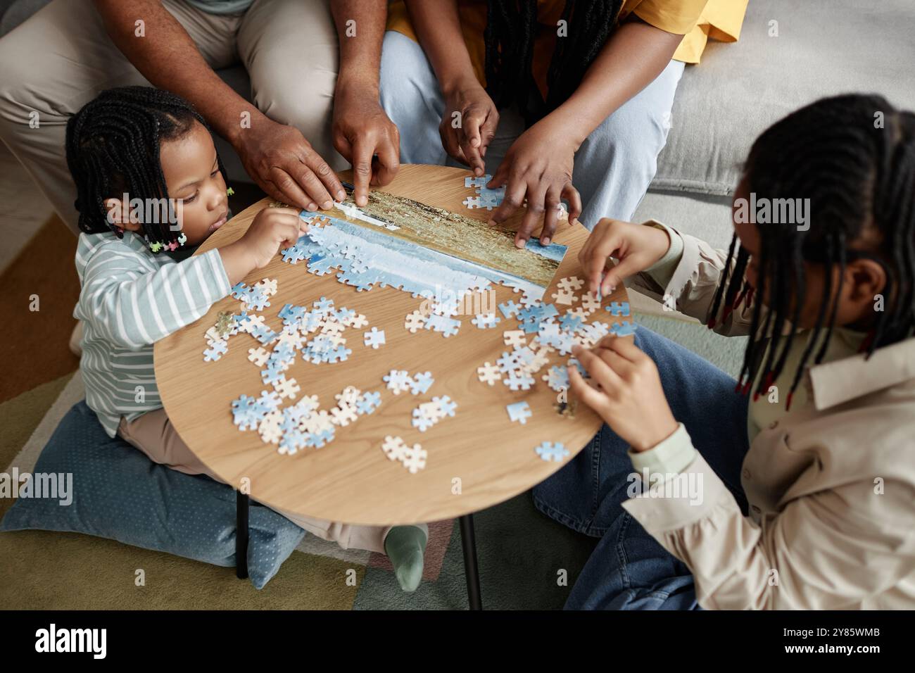 Cozy living room with family engaging in puzzle activity, children and ...