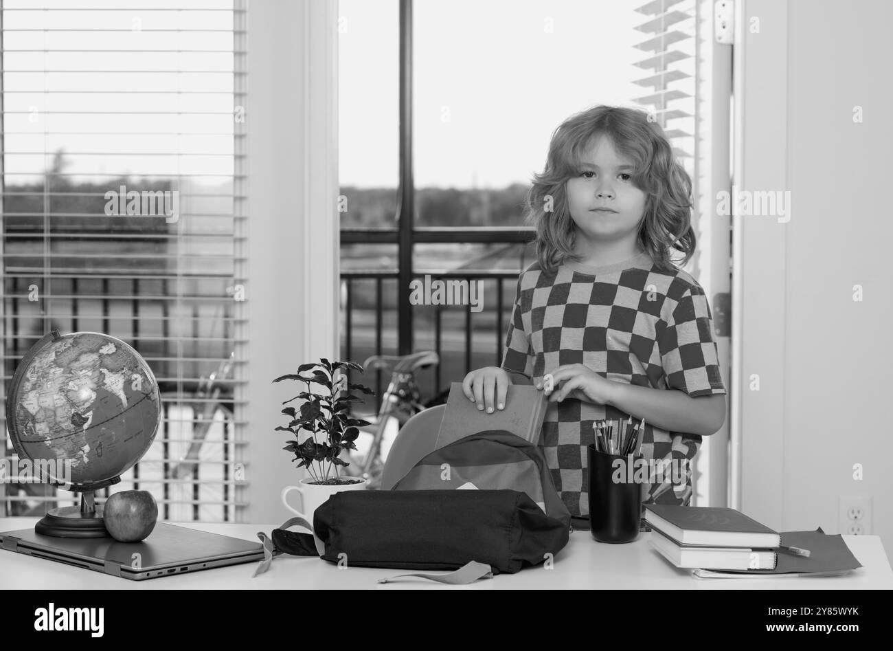 School child puts school supplies in a backpack. Preparation for school ...