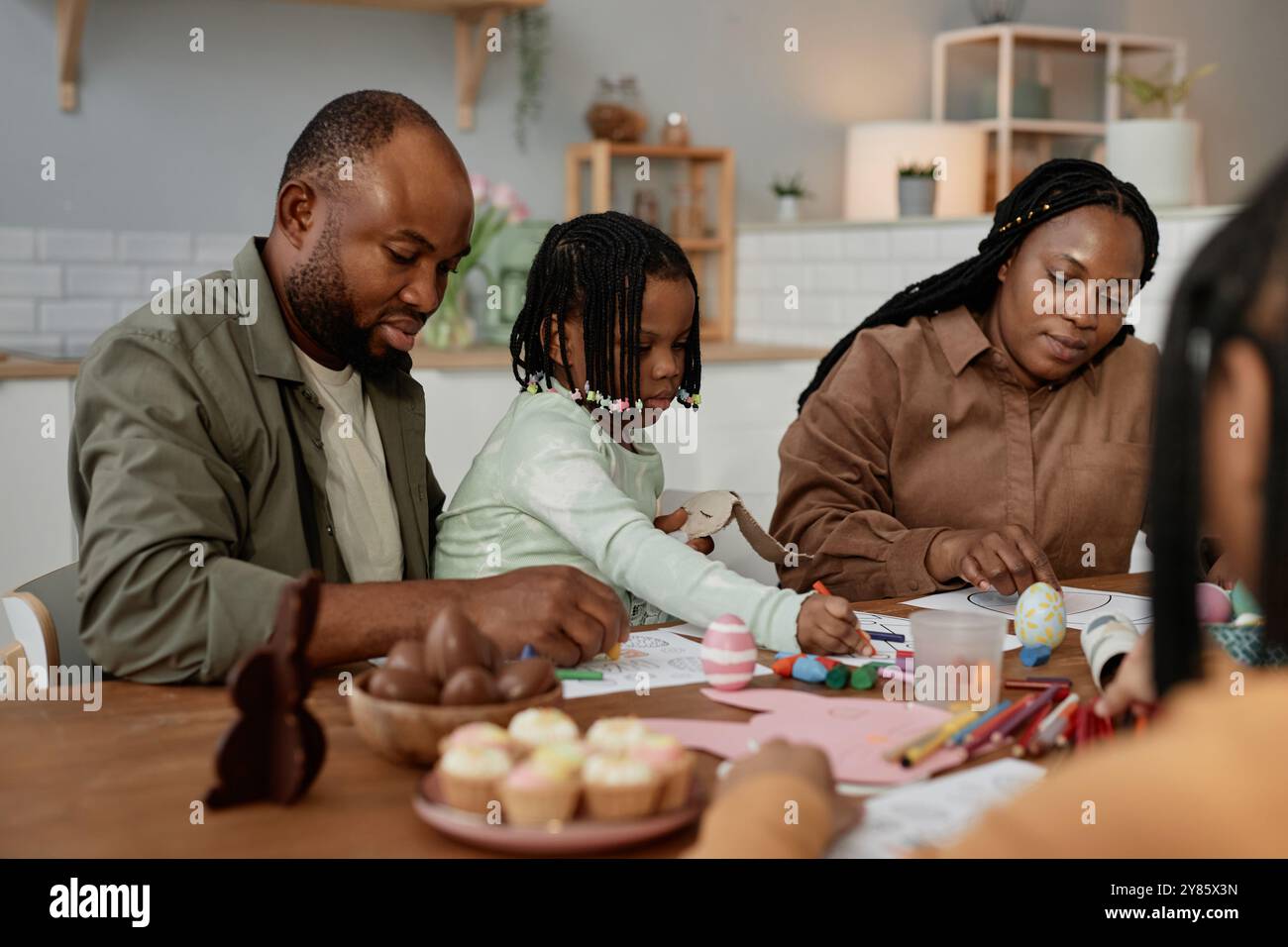 African American family enjoying time together creating art projects at ...