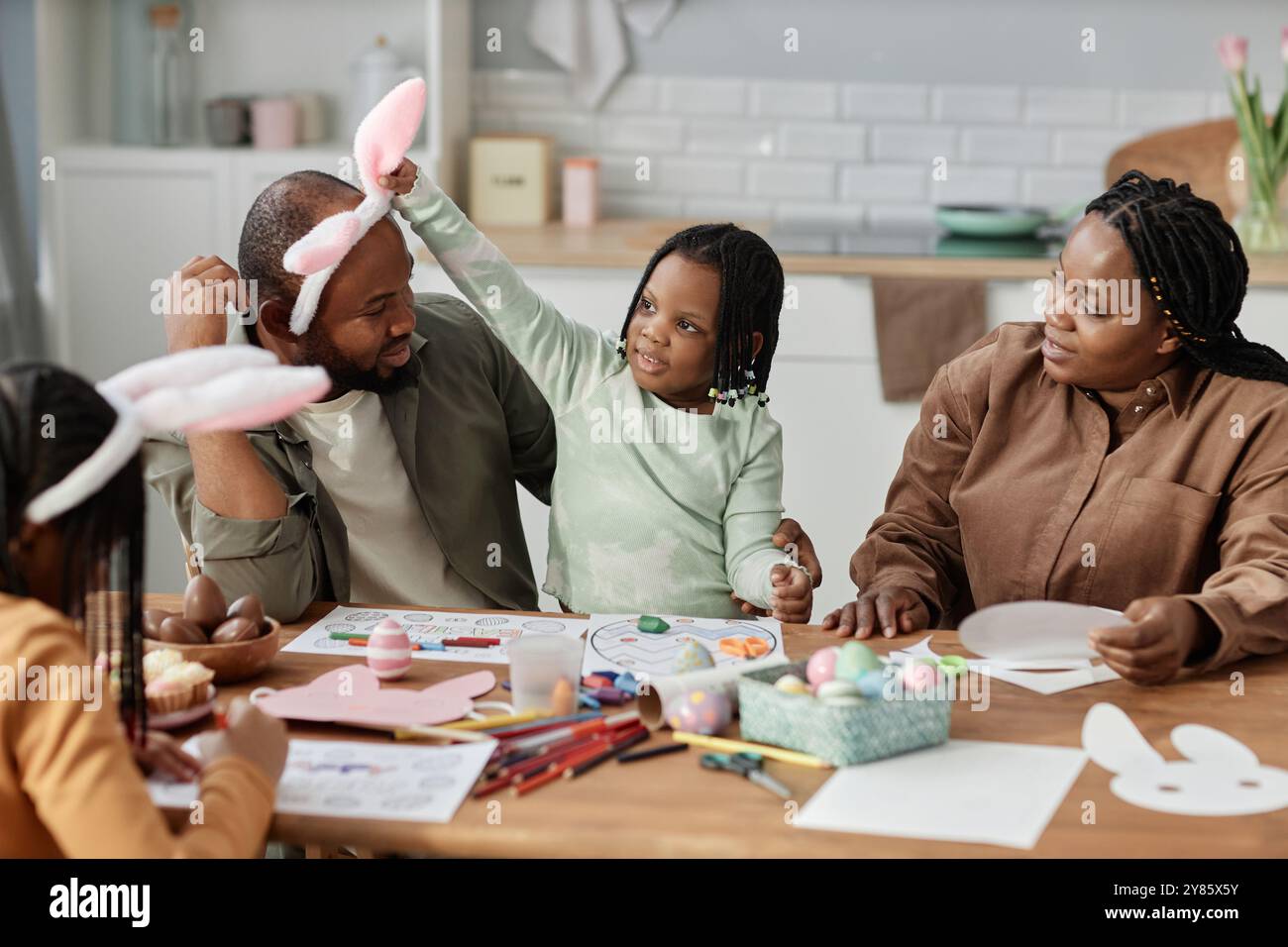 African American family enjoying time together while making Easter ...