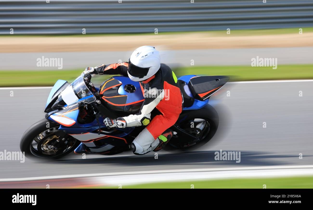 Racing bike rider leaning into a fast corner on the race track ...