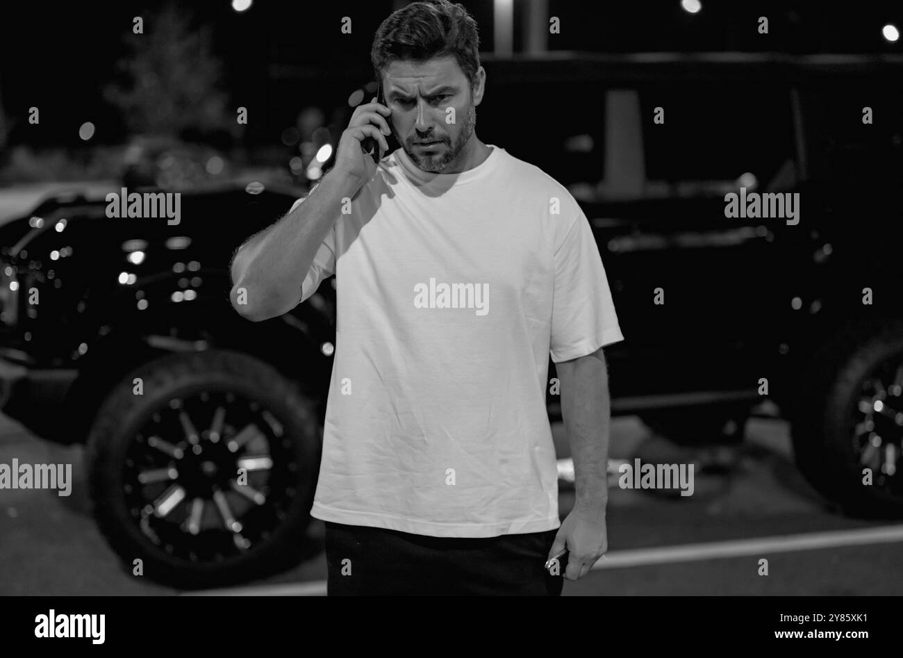 Angry man talking on phone on night urban street. Dangerous aggressive ...