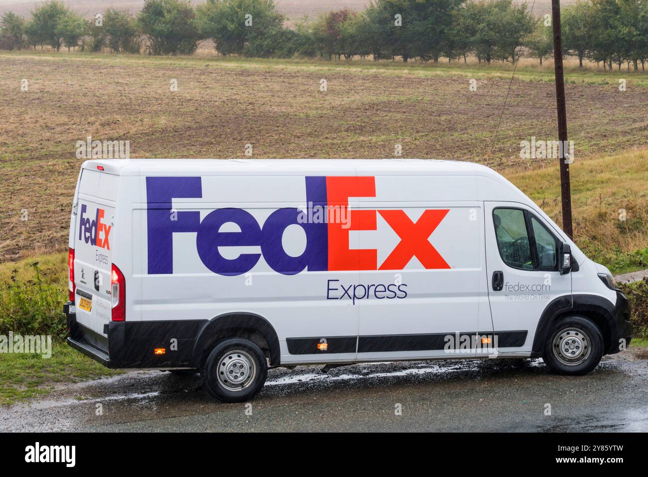 A FedEx delivery van parked on a Norfolk country lane in the rain Stock ...