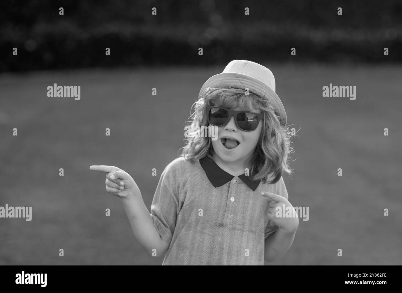 Kid point finger. Portrait of kid in spring park outdoors. Close-up ...