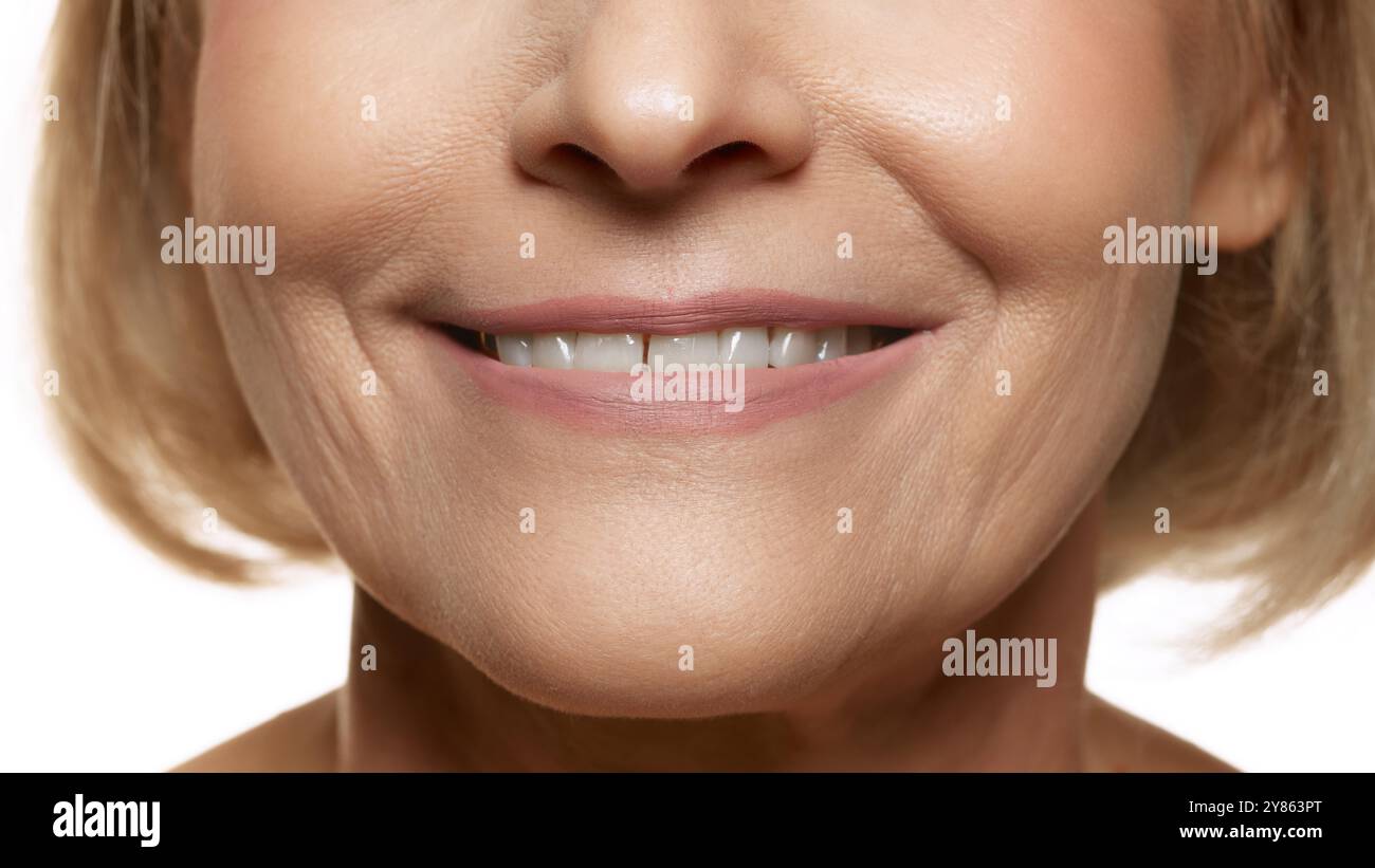 Close-up of smiling woman's mouth, showing natural skin texture and ...