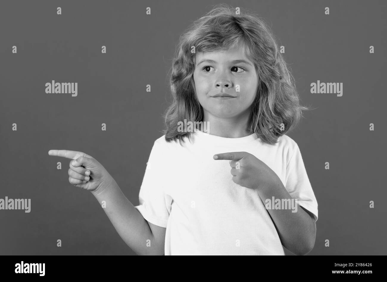 Kid boy pointing away on blue isolated studio background. Kid with ...
