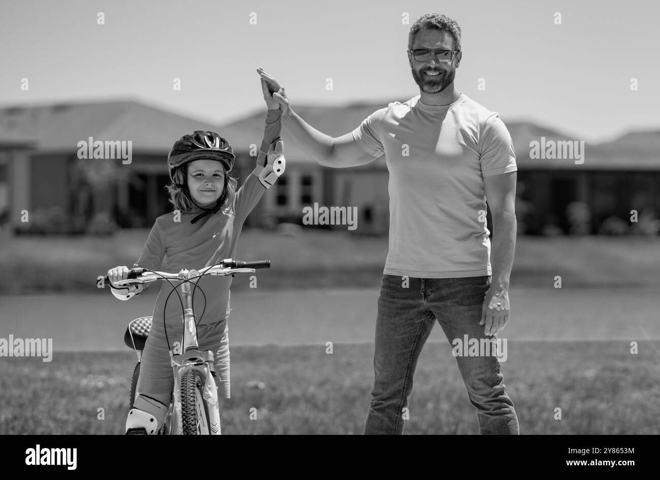 Happy Fathers day. Father support son. Father and son in a helmet riding bike. Little cute ...