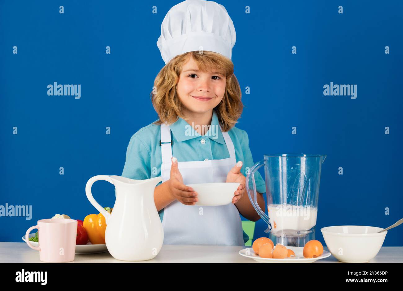 Child chef isolated on blue. Funny little kid chef cook wearing uniform ...